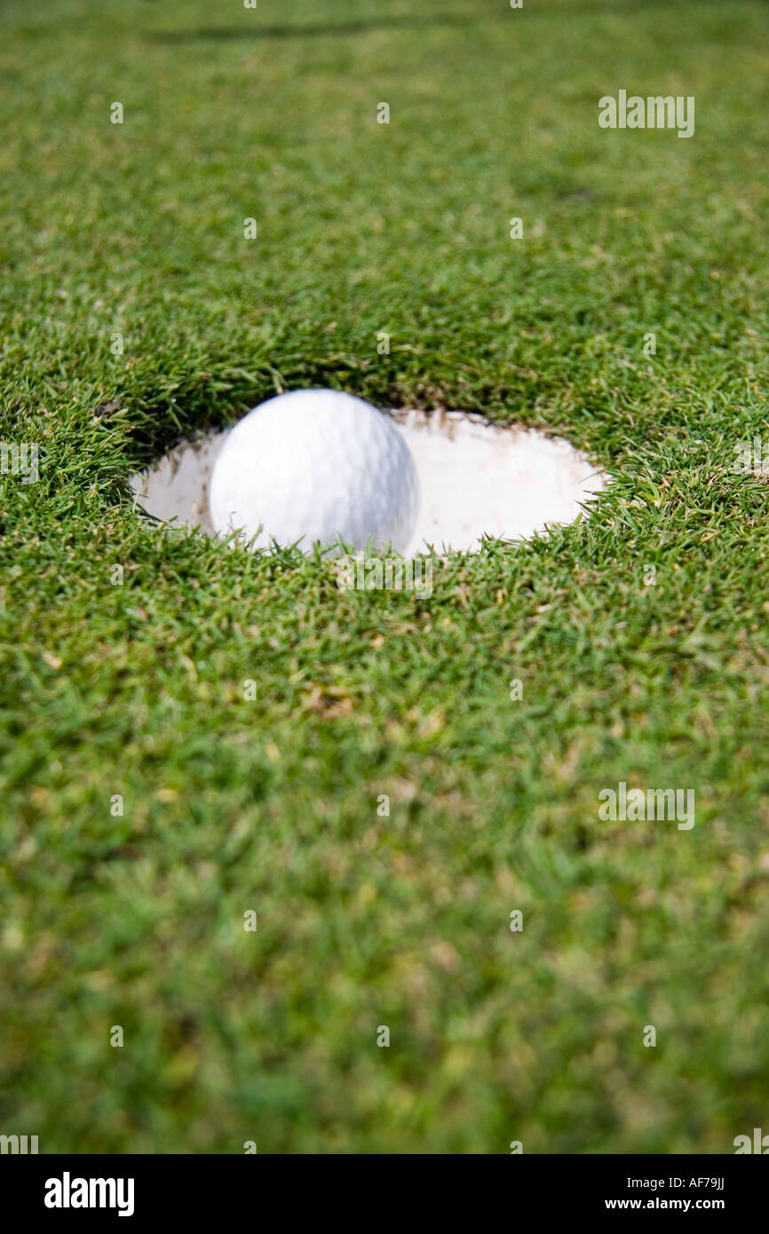 Golf ball falling into hole Stock Photo - Alamy