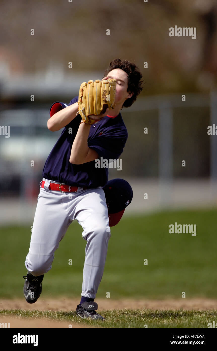Baseball player catching baseball with hat flying off Stock Photo - Alamy