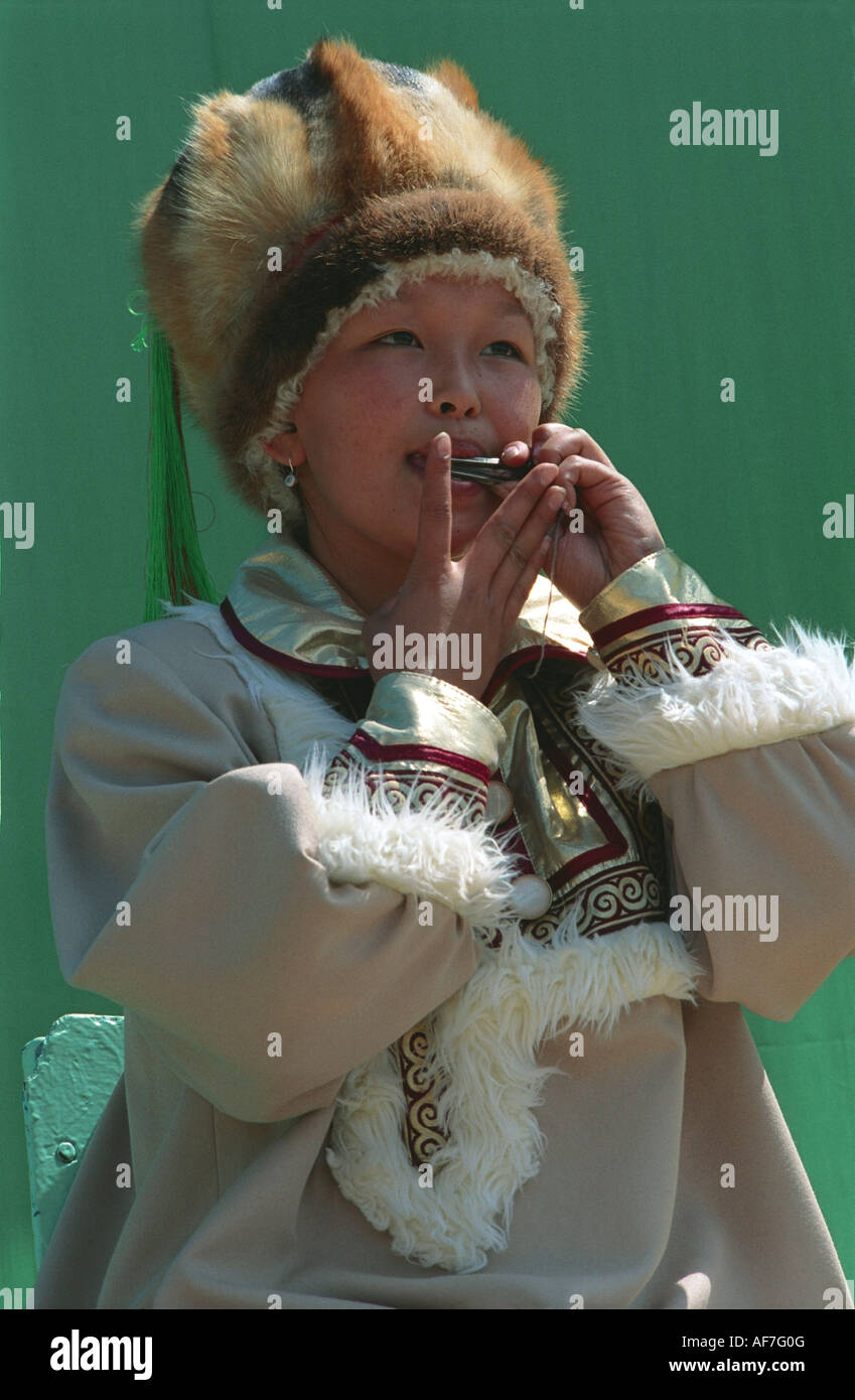Portrait of a young girl playing national Altaic instrument komus. El ...
