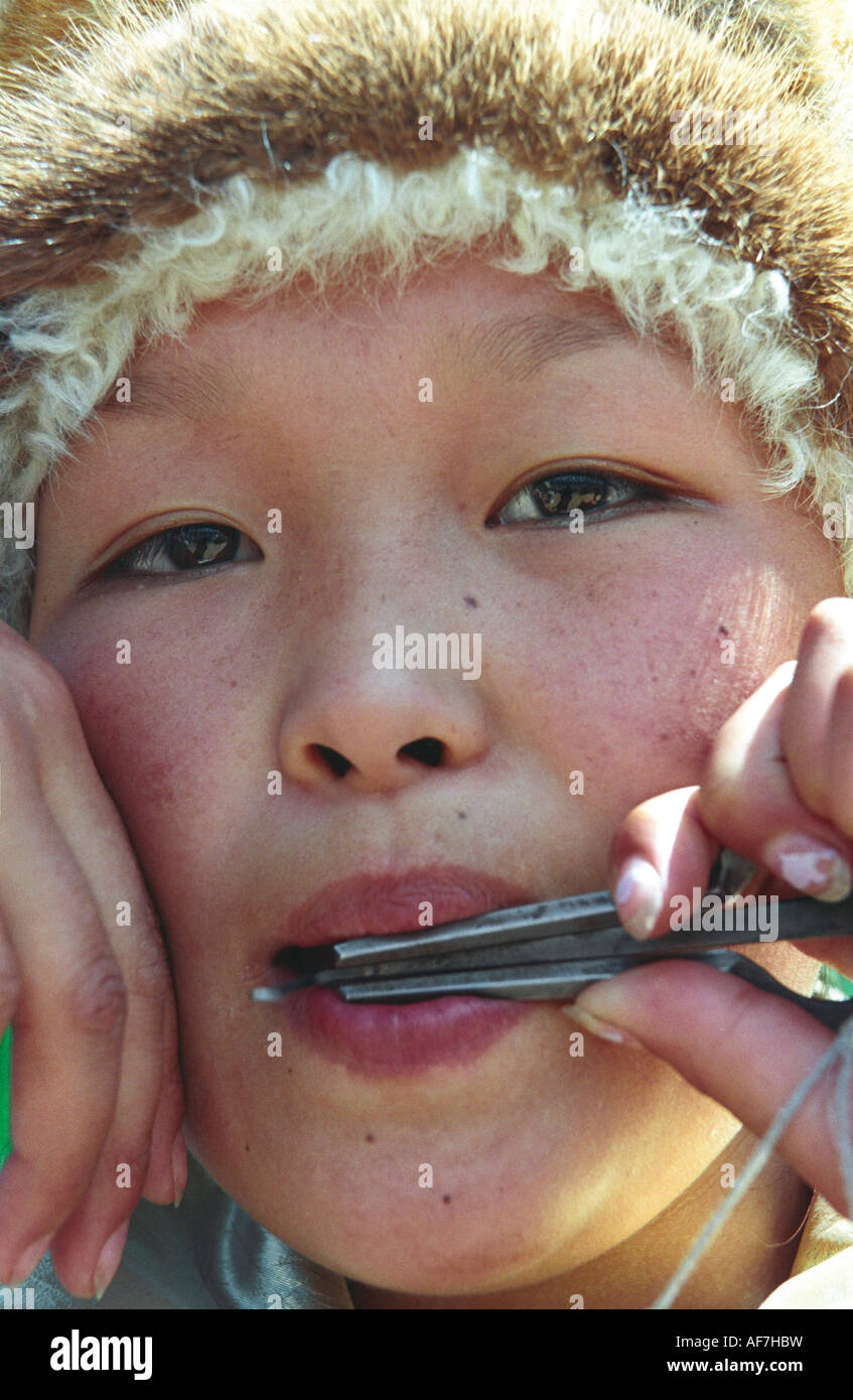Portrait of a young girl playing national Altaic instrument komus. El ...