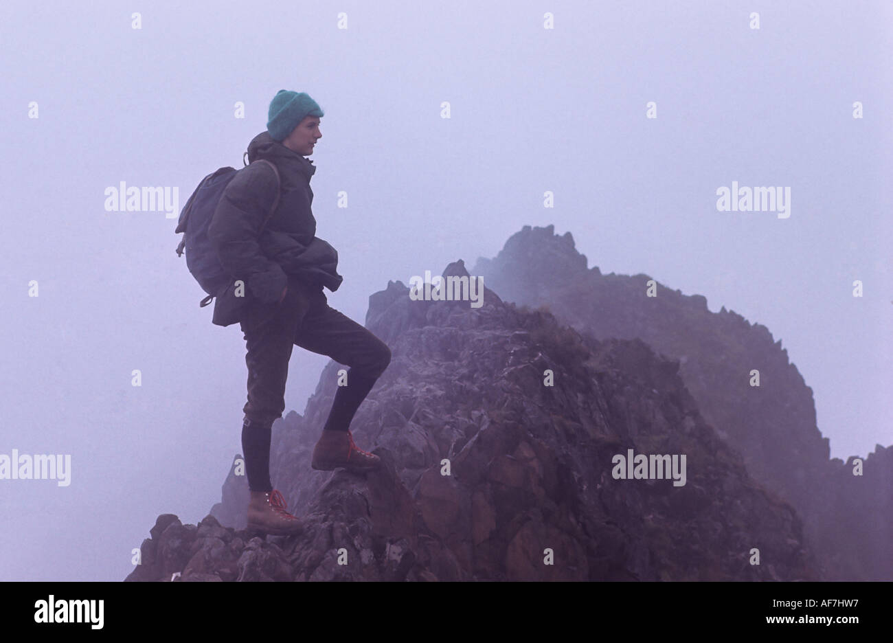 Woman climber on Crib Goch Ridge, part of the Snowdon Horshoe route to ...