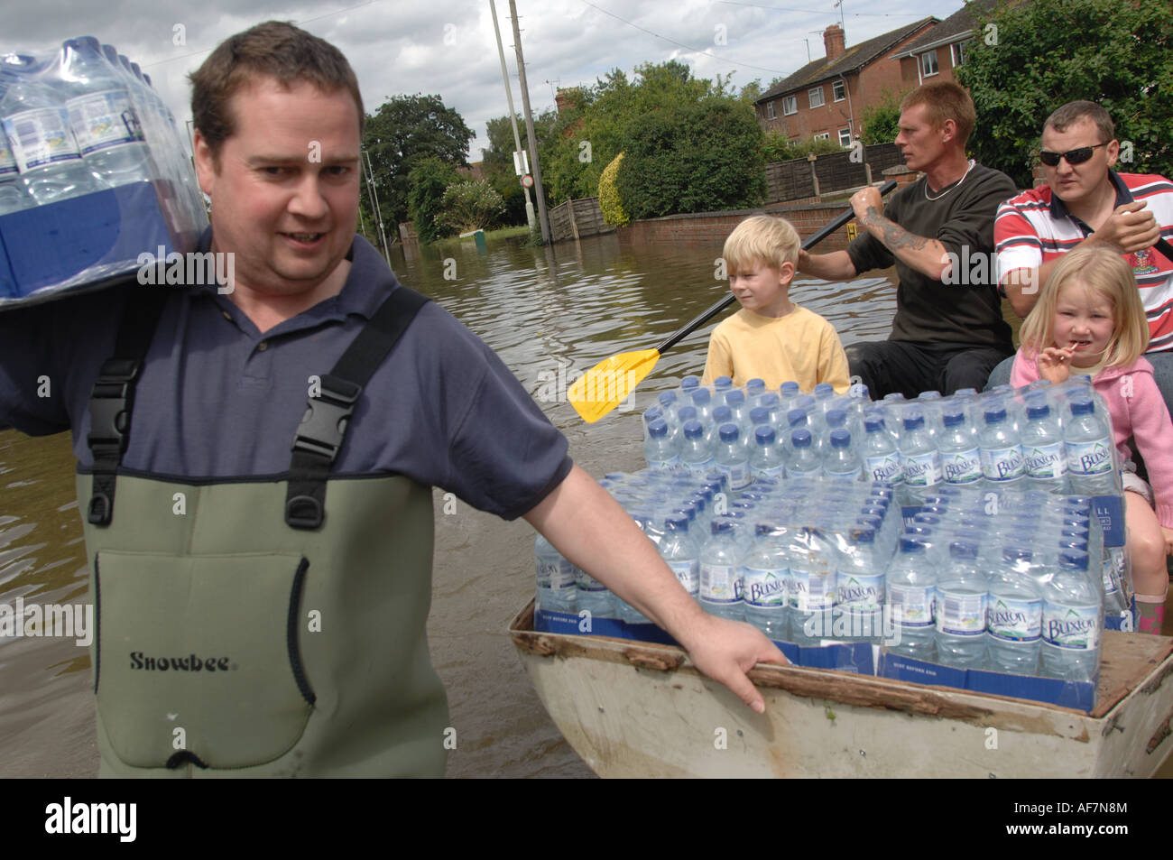Family use a boat to deliver drinking water to neighbours during floods ...
