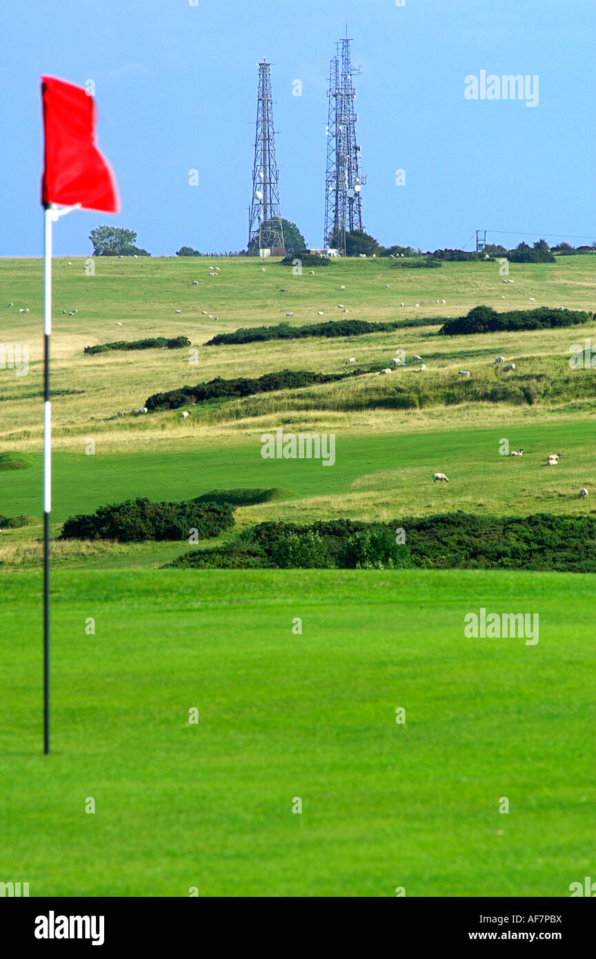 golf course with flag and communication transmitters in the background ...