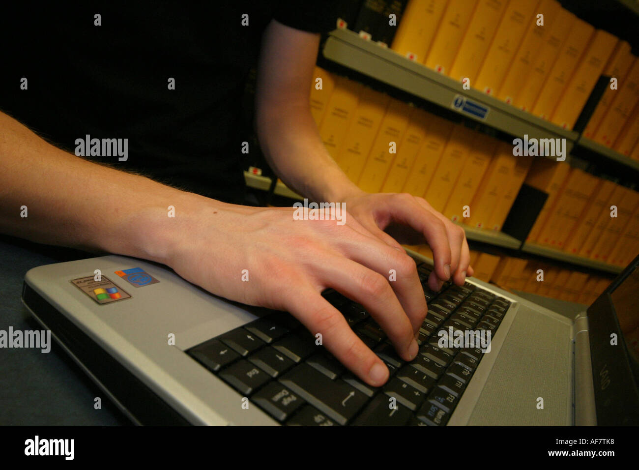 A Stock Photograph of a University Student Reading Books and Typing on ...