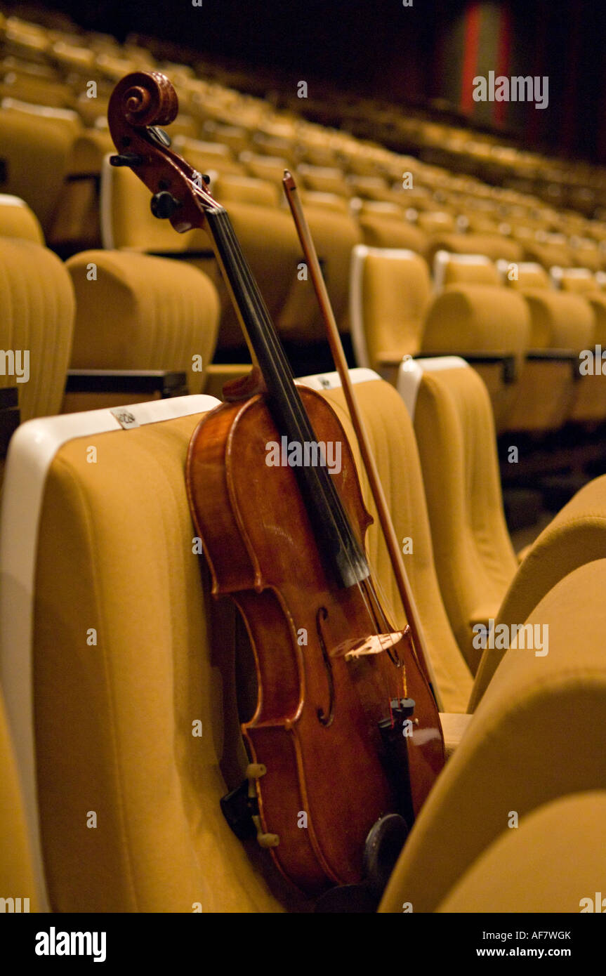 Violin placed in an armchair in a concert hall Stock Photo - Alamy