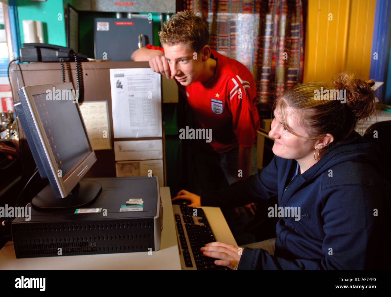 A TEENAGE GIRL AND BOY USING A COMPUTER IN A YOUTH CLUB UK Stock Photo ...
