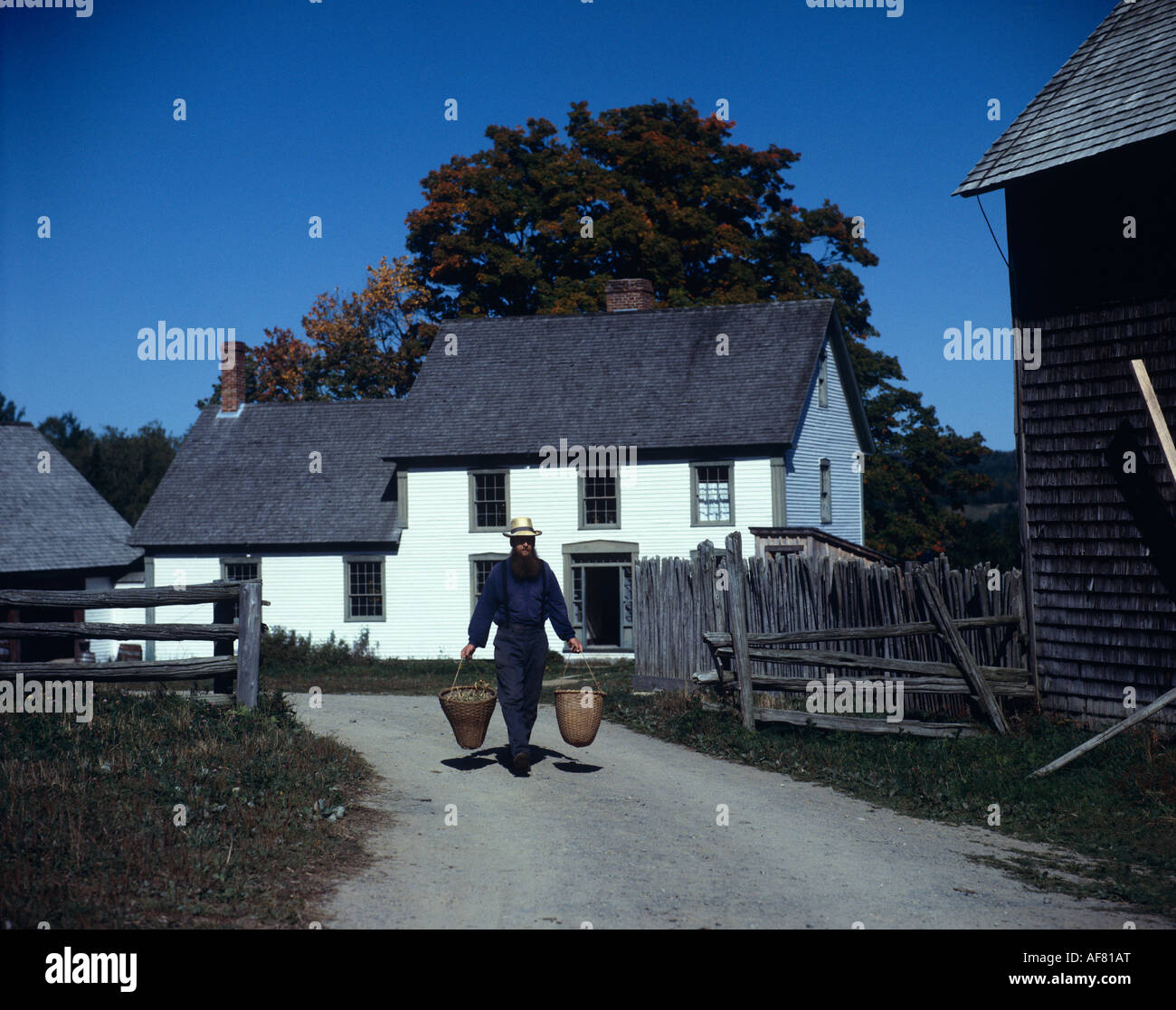 Man carrying baskets on farm Stock Photo - Alamy