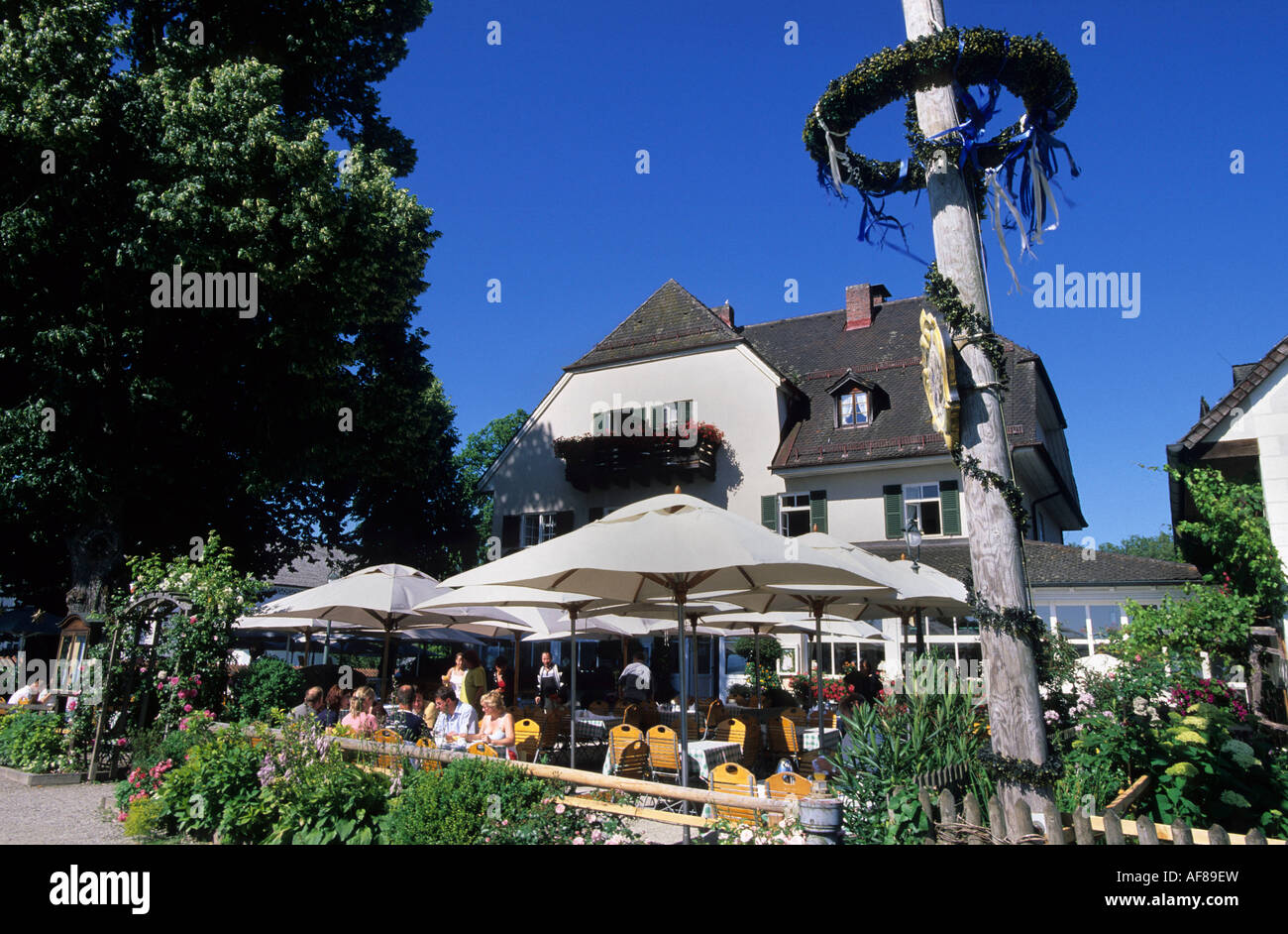 beer garden of restaurant Zur Linde with maypole, island of Fraueninsel ...