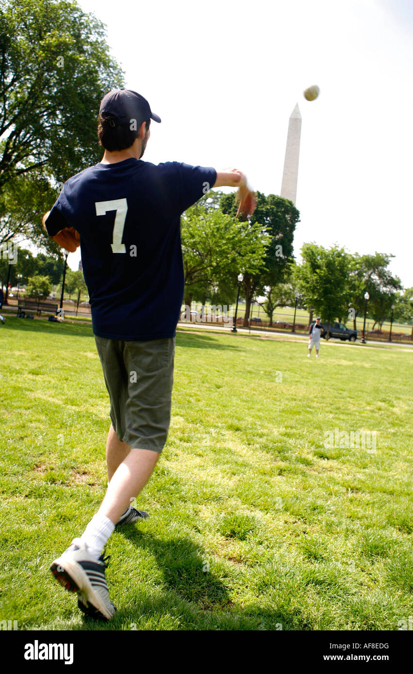 A young man throwing a ball on a meadow, The National Mall, Washington ...