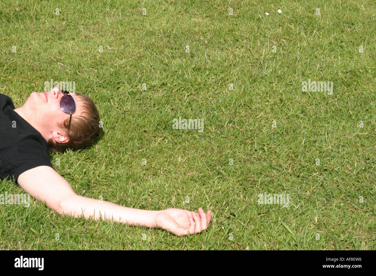 A Stock Photograph of a University Student Laying on Grass Relaxing in ...
