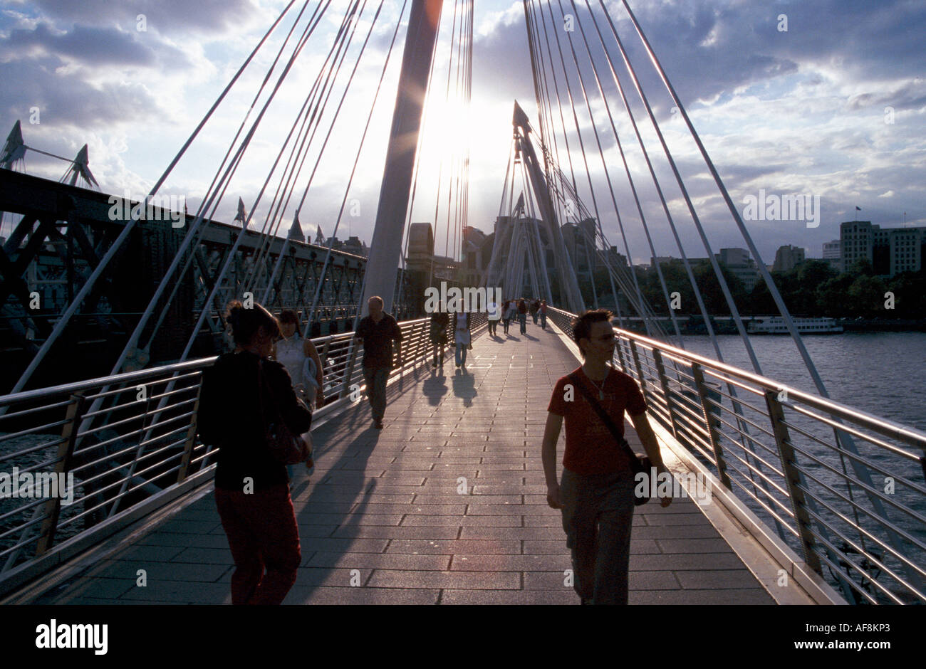 People walking across golden jubilee bridge hi-res stock photography ...