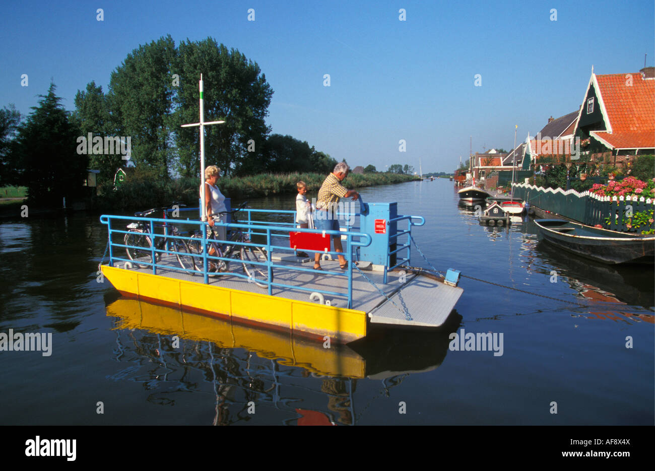 Netherlands Oost Knollendam People on little ferry Man pulling rope ...