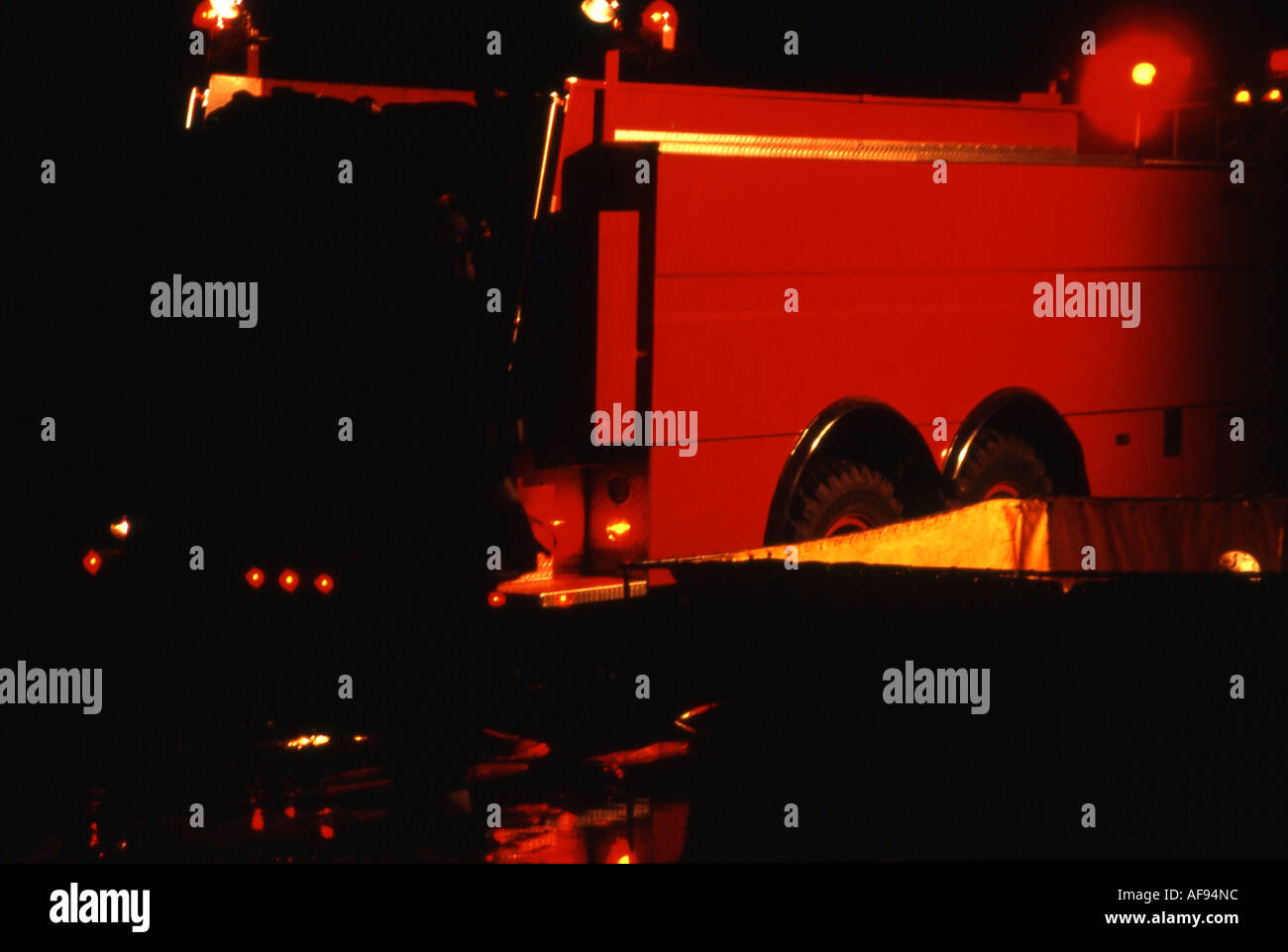A fire truck tanker and tank on a landfill fire scene at night Stock ...