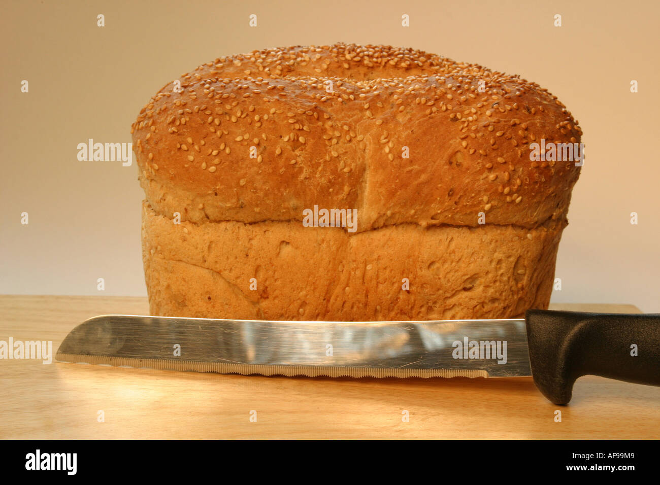 A Stock Photograph of a Loaf of Bread and a Knife Cutting it Stock ...