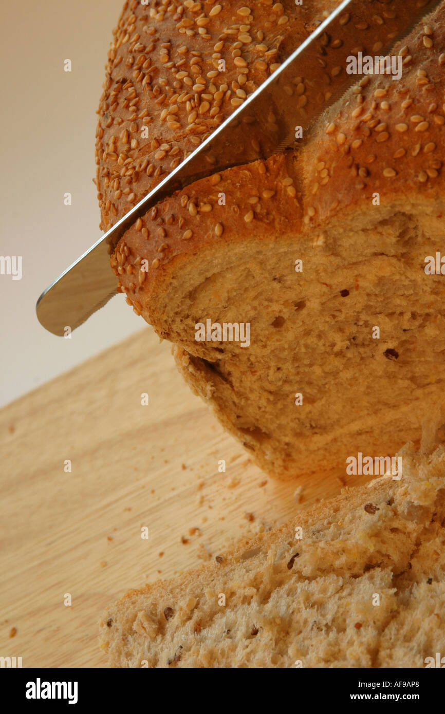 A Stock Photograph of a Loaf of Bread and a Knife Cutting it Stock ...