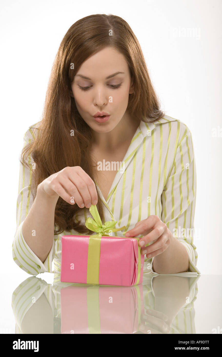 Young woman opening pink present, portrait Stock Photo - Alamy