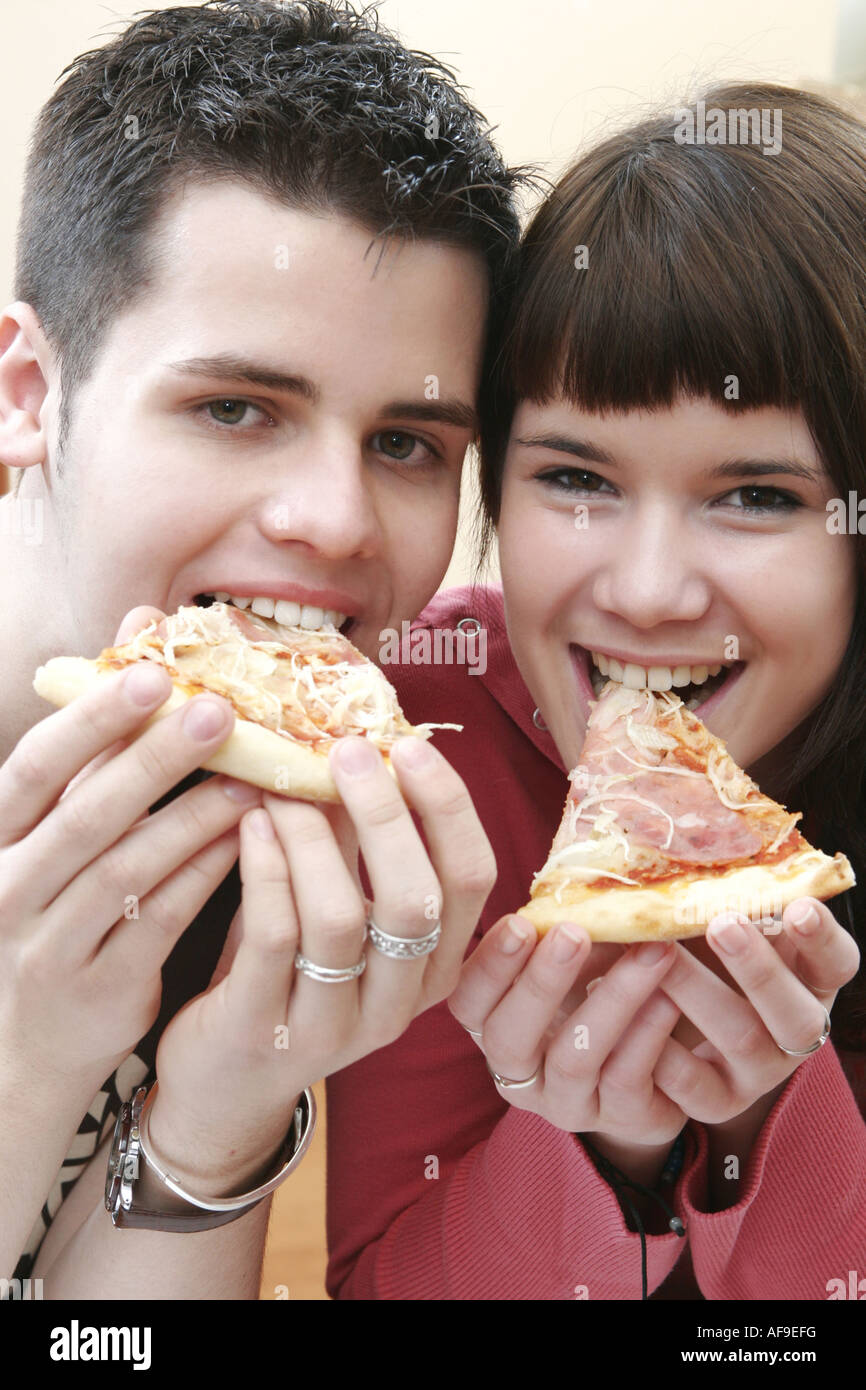Teenage couple is eating fast food pizza Stock Photo - Alamy