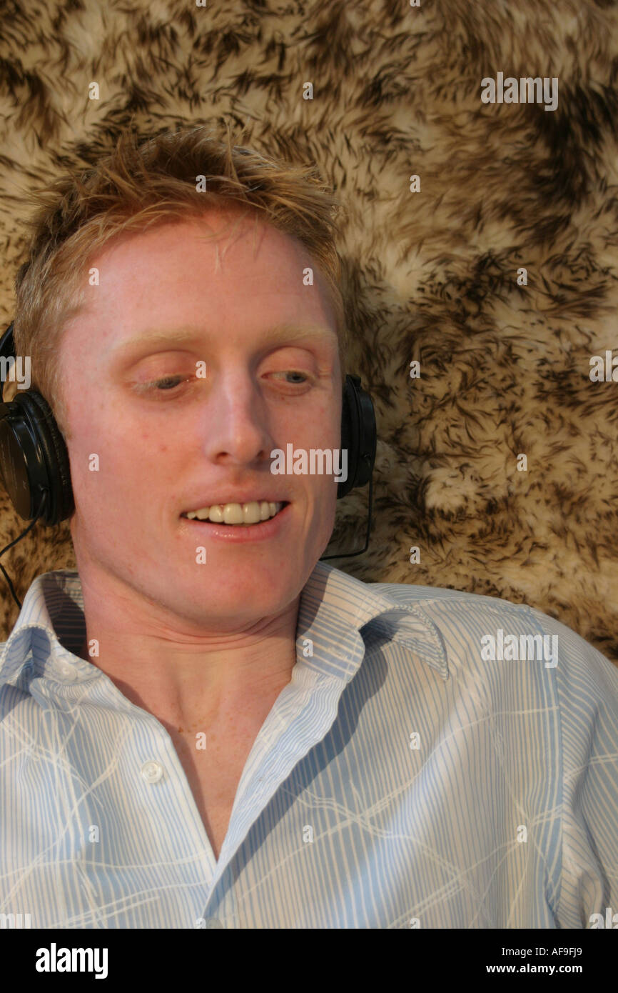 A Stock Photograph of a Man Laying Down on a Carpet Listening to Music ...