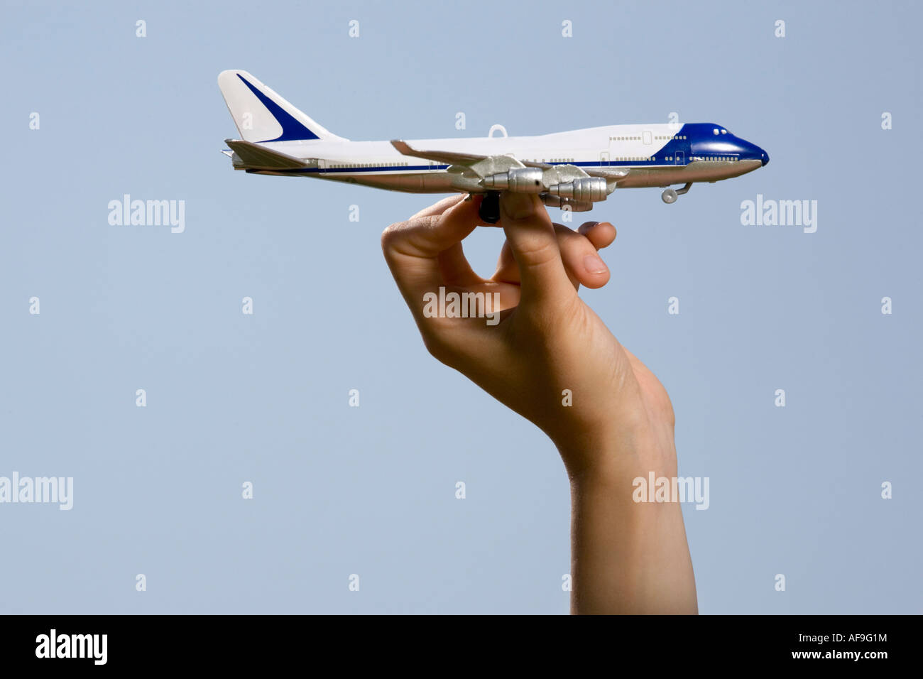 Hand holding toy airplane Stock Photo - Alamy