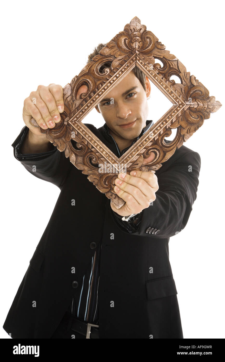 Young man holding picture frame, close-up Stock Photo - Alamy
