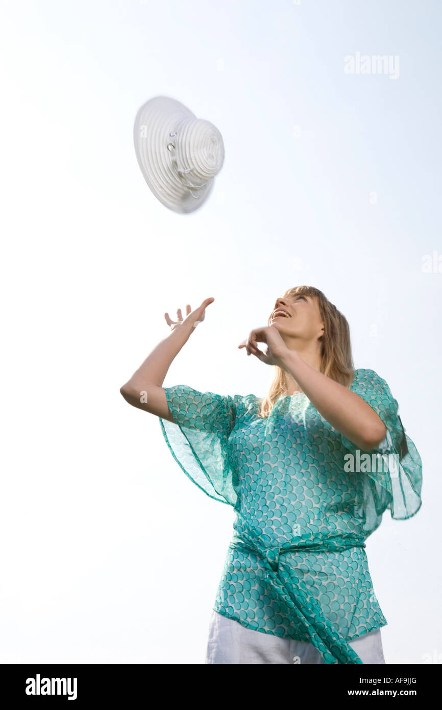 Young woman throwing a hat Stock Photo - Alamy
