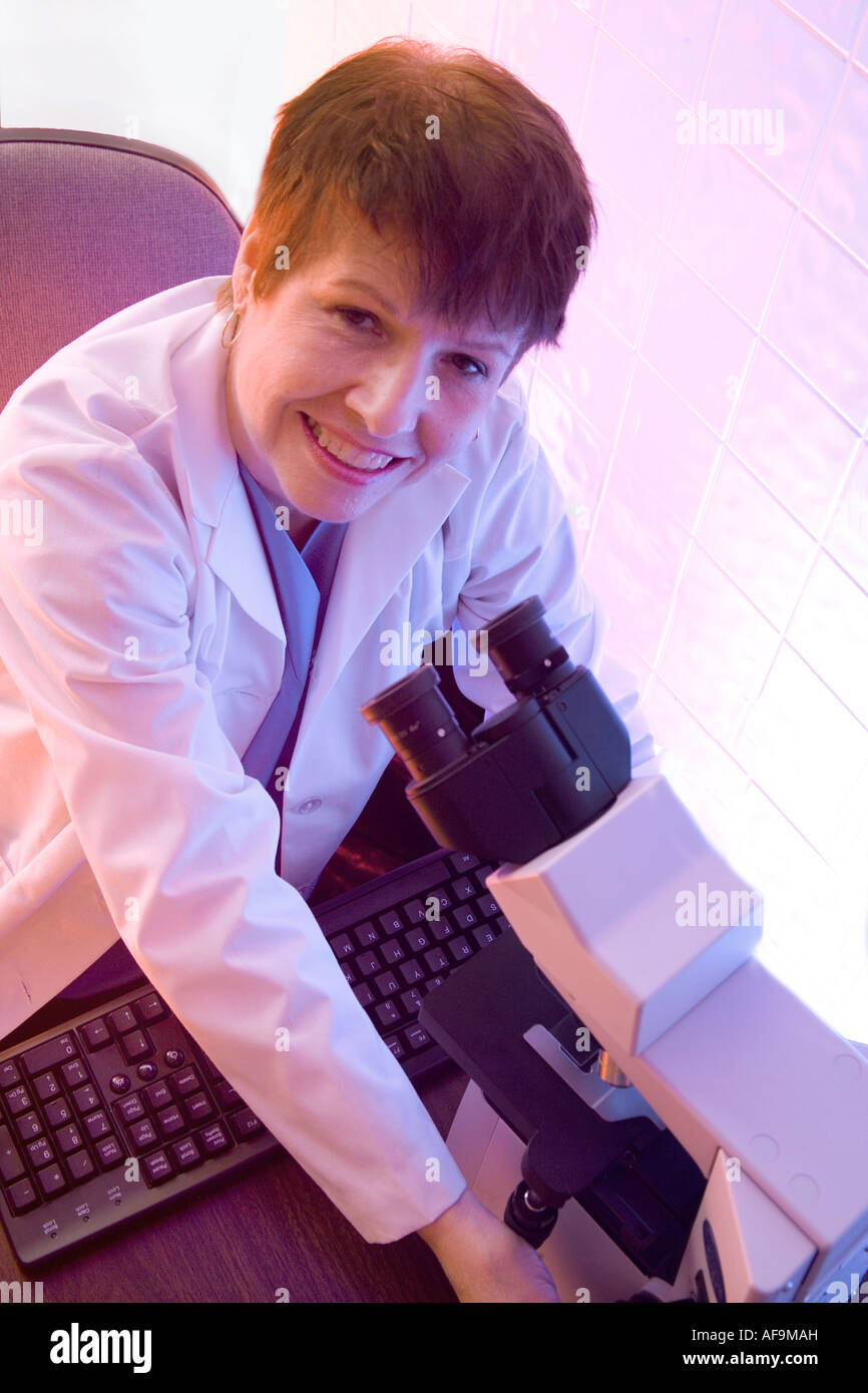 Female researcher using microscope Stock Photo - Alamy