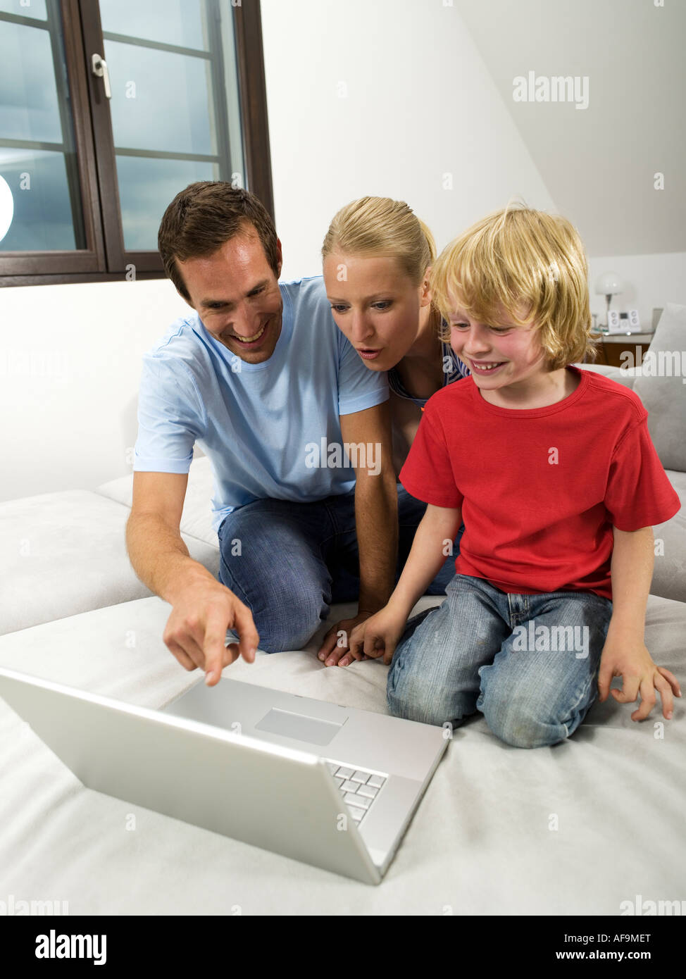 Family using laptop Stock Photo - Alamy