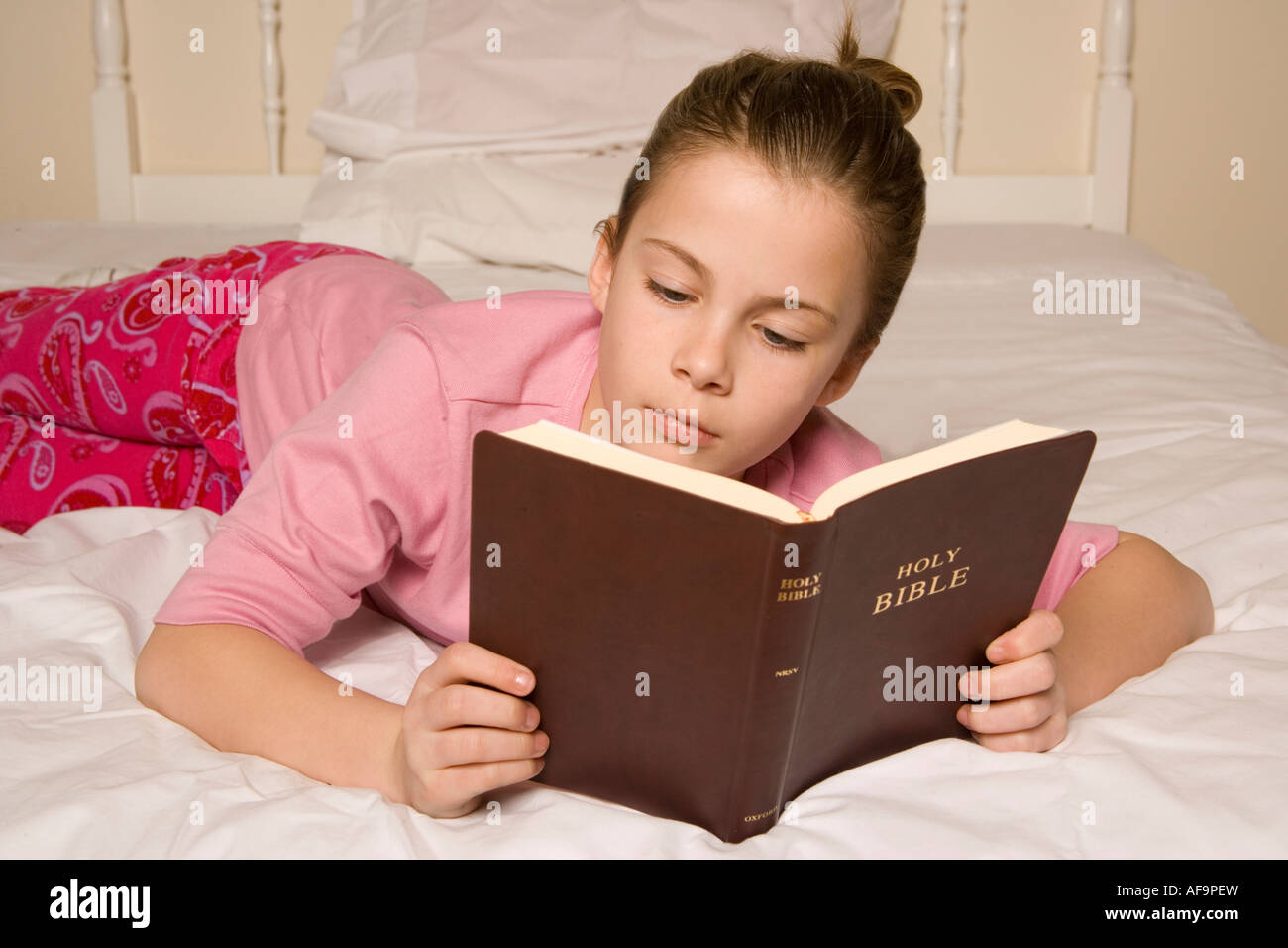 Girl reading bible in bed hi-res stock photography and images - Alamy