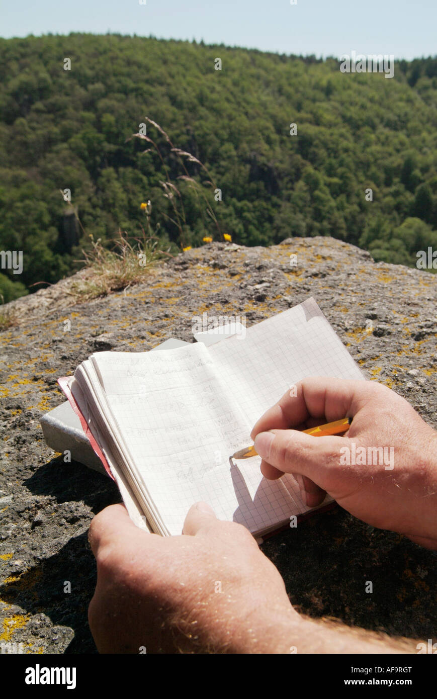 Man writing notes in notebook Stock Photo - Alamy