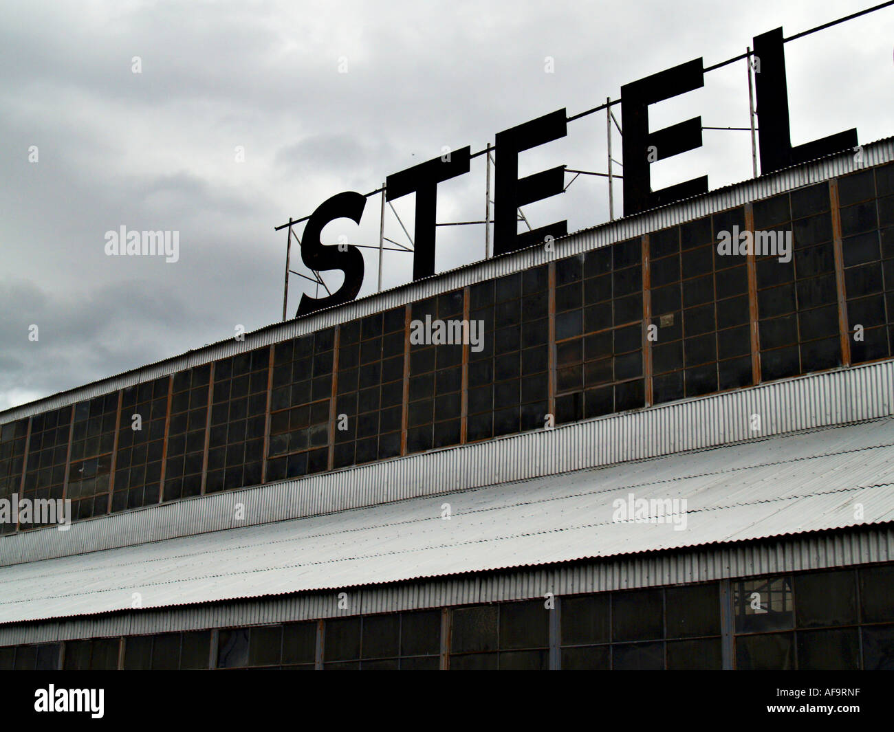 Large sign reading STEEL against a grey cloudy sky on the top of a ...