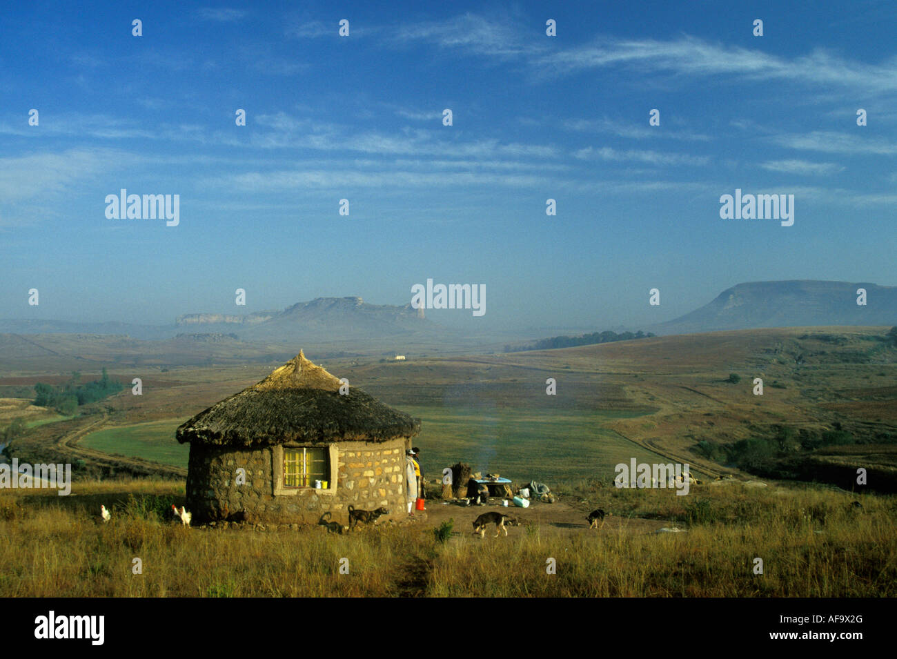 A traditional stone and thatch homestead in Lesotho against a backdrop ...