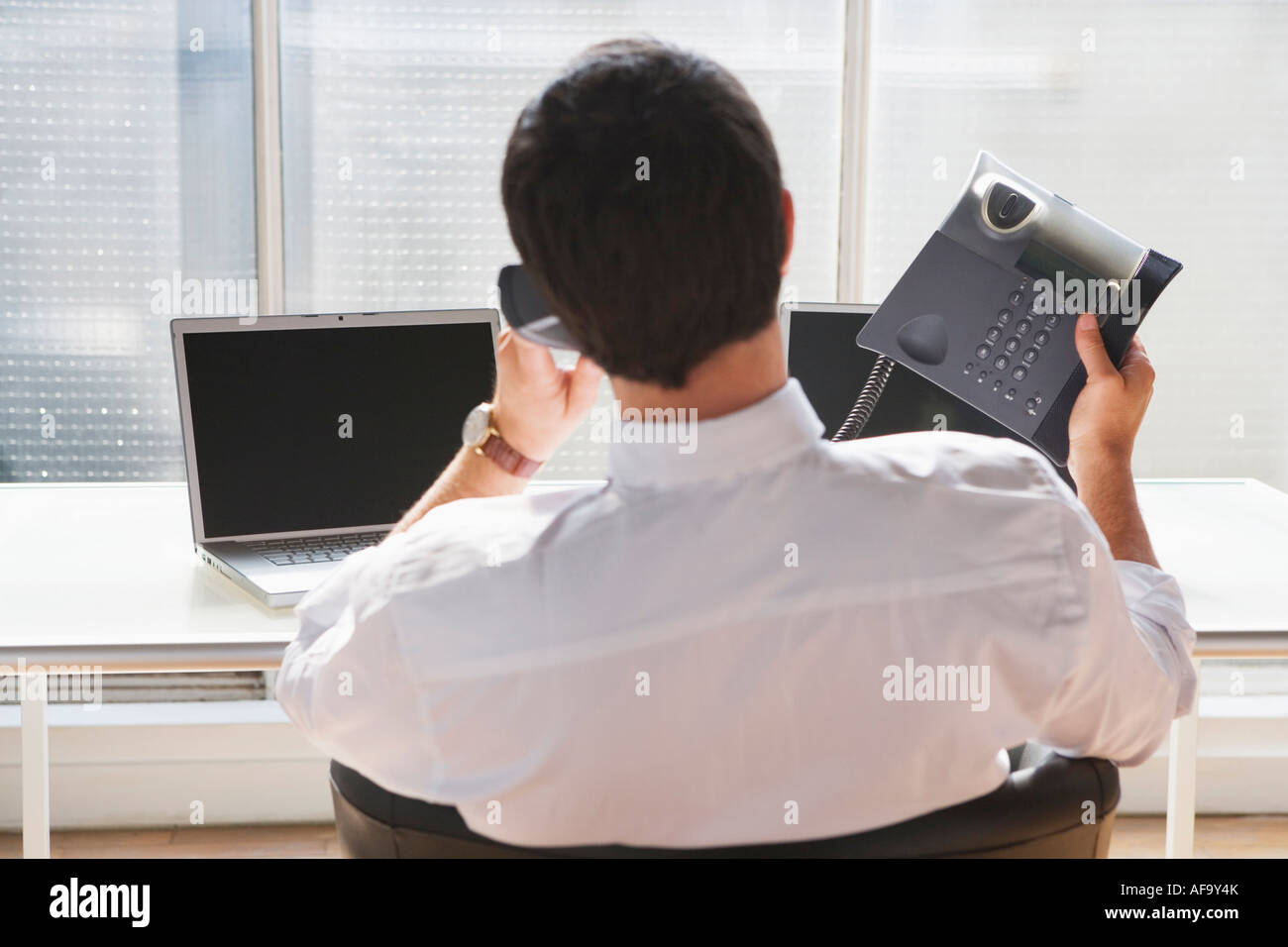 Business man using phone, rear view Stock Photo - Alamy