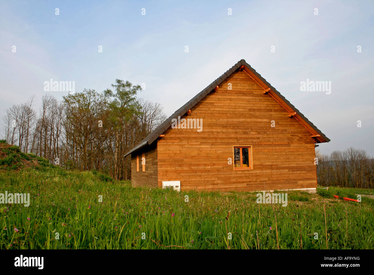 wooden house in green field Stock Photo - Alamy