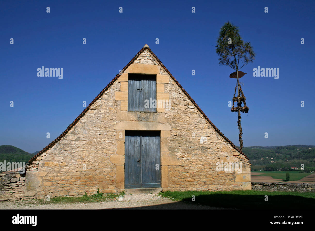 triangular farm barn with tall tree and blue sky Stock Photo - Alamy