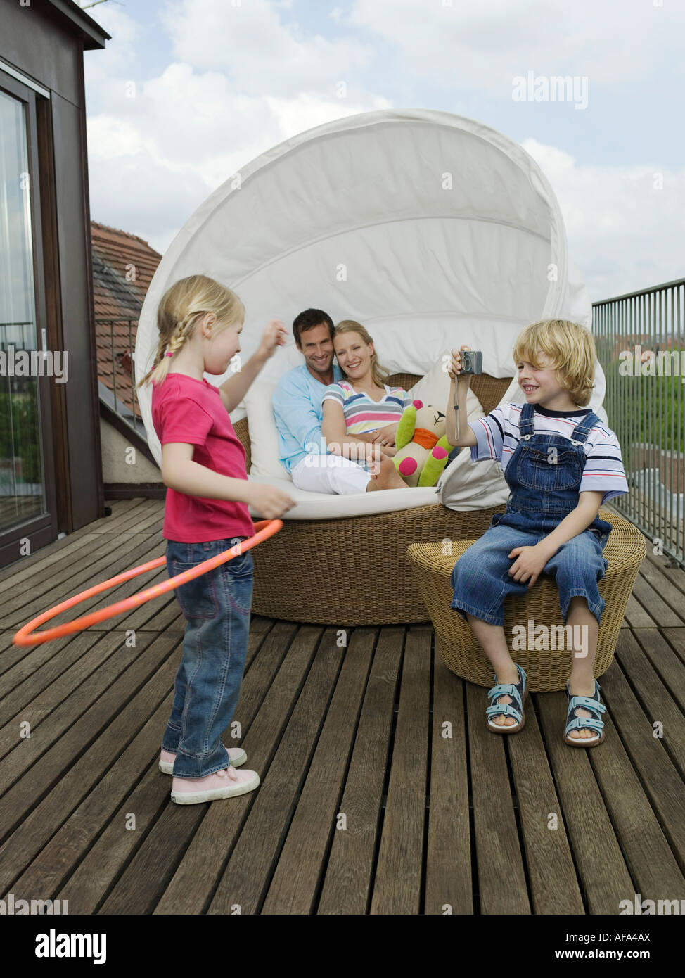 Family on balcony, children playing Stock Photo - Alamy