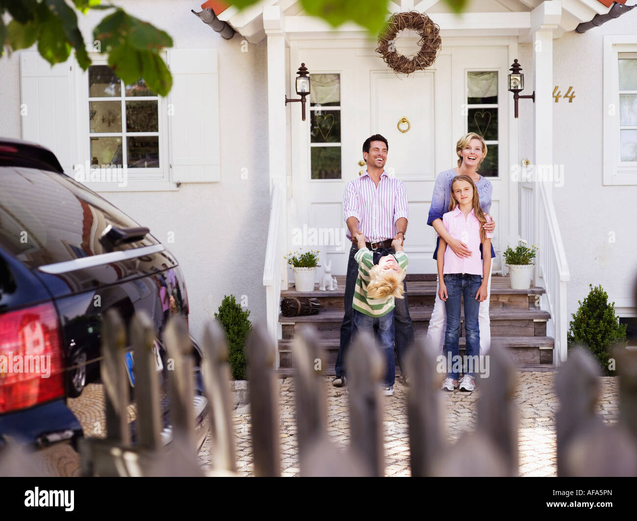 Family in front of house Stock Photo - Alamy