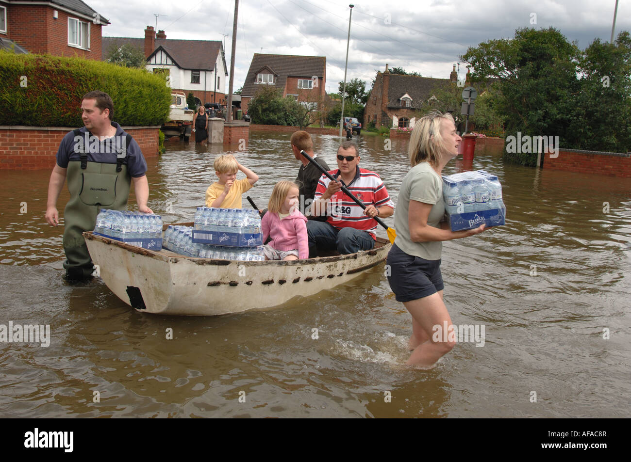 A family us a boat to deliver drinking water to neighbours during ...