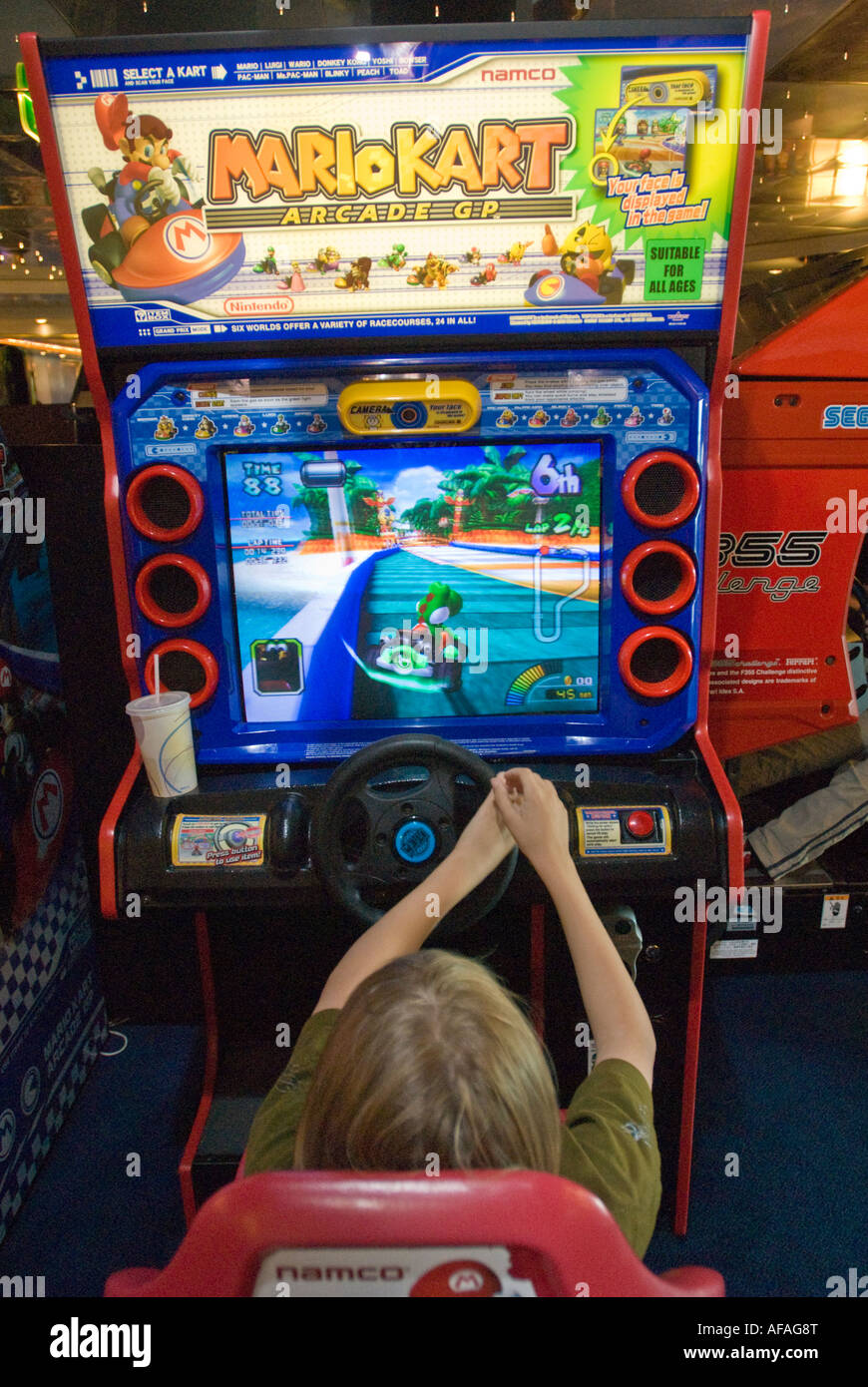 A youngster playing on an arcade game machine Stock Photo - Alamy