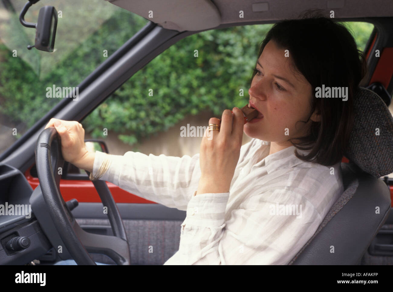 woman eating while driving Stock Photo - Alamy