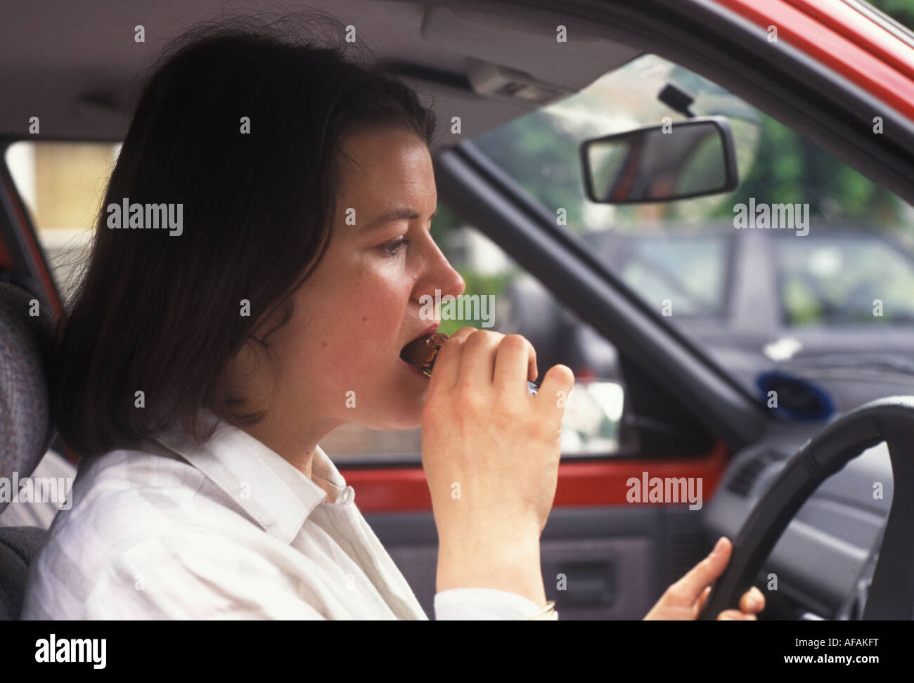 Woman eating chocolate driving hi-res stock photography and images - Alamy