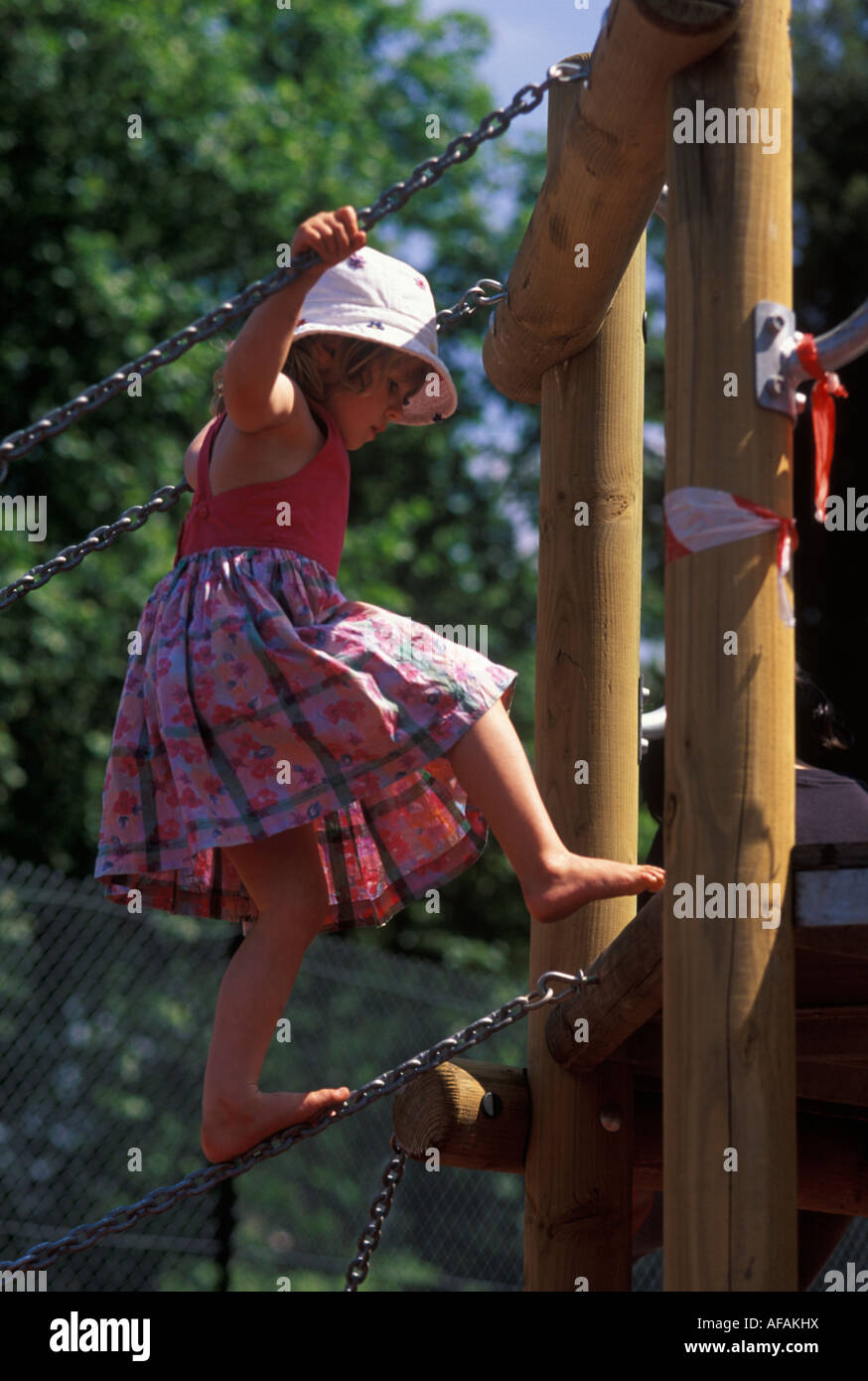 girl walking along a chain tight rope Stock Photo - Alamy