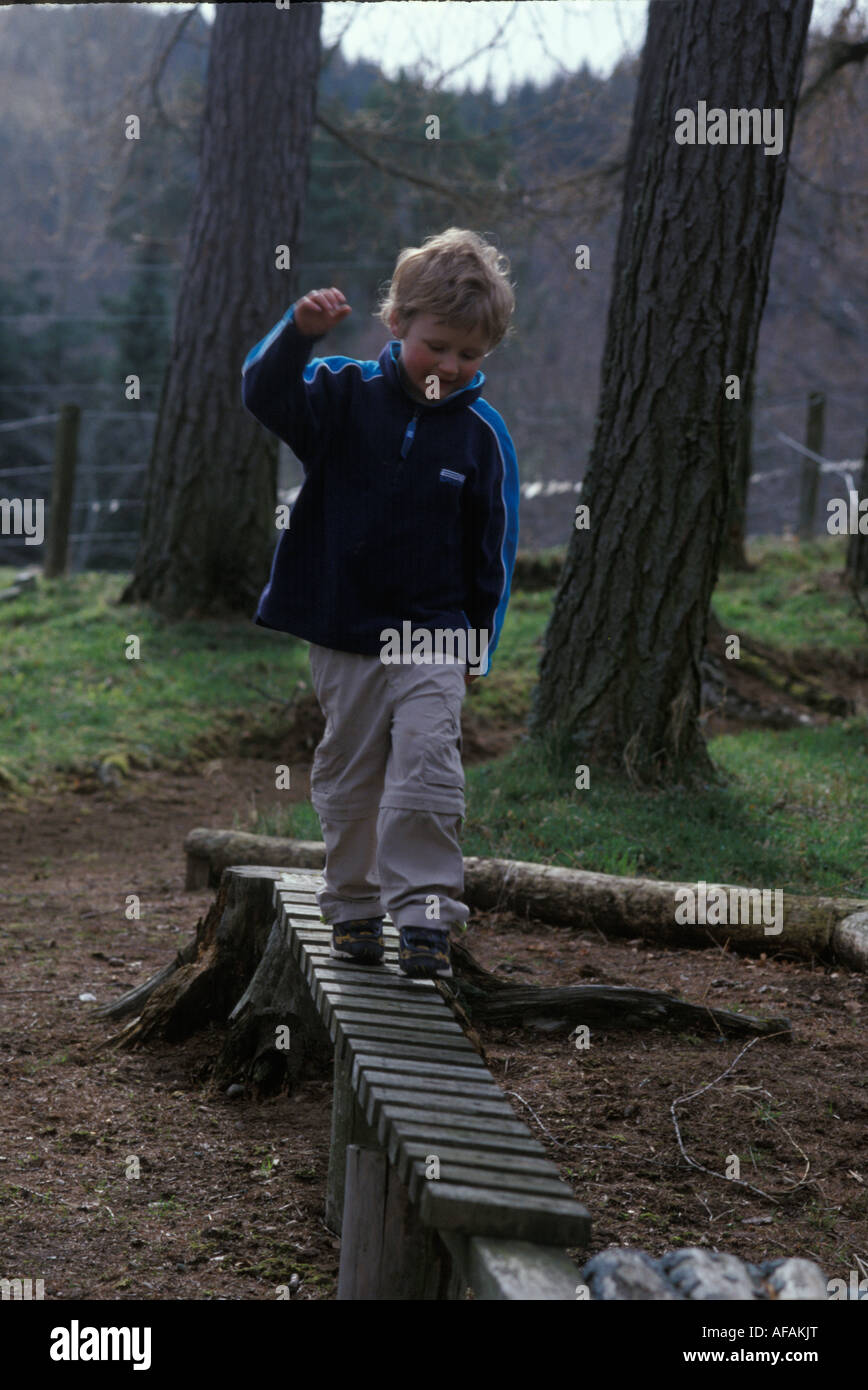 boy leaping walking along a ramp in children s natural playground Stock ...
