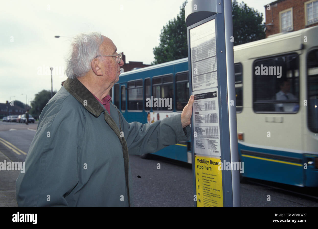 pensioner looking at bus time table Stock Photo - Alamy