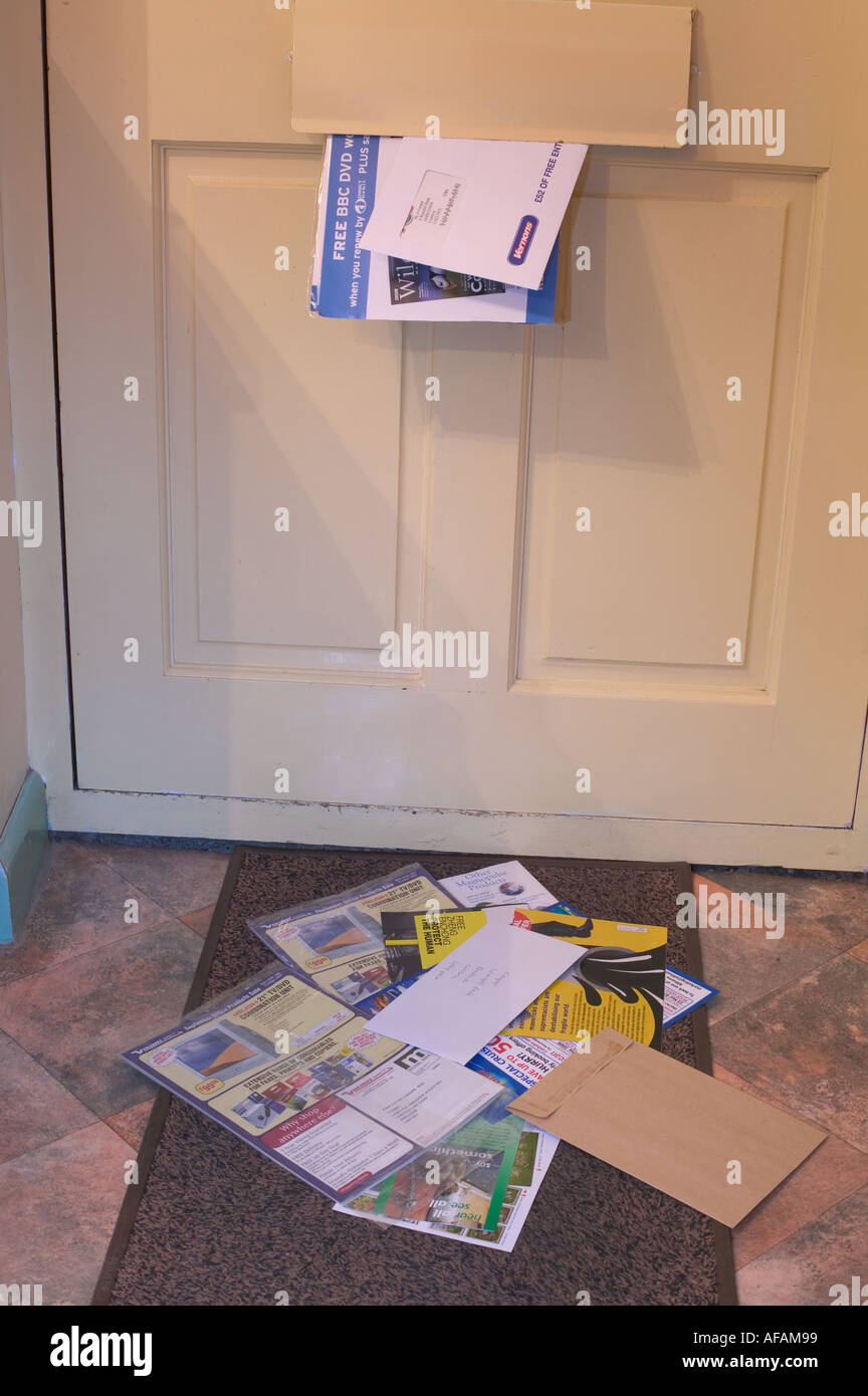 post coming through a letterbox of a house front door and lying on the ...