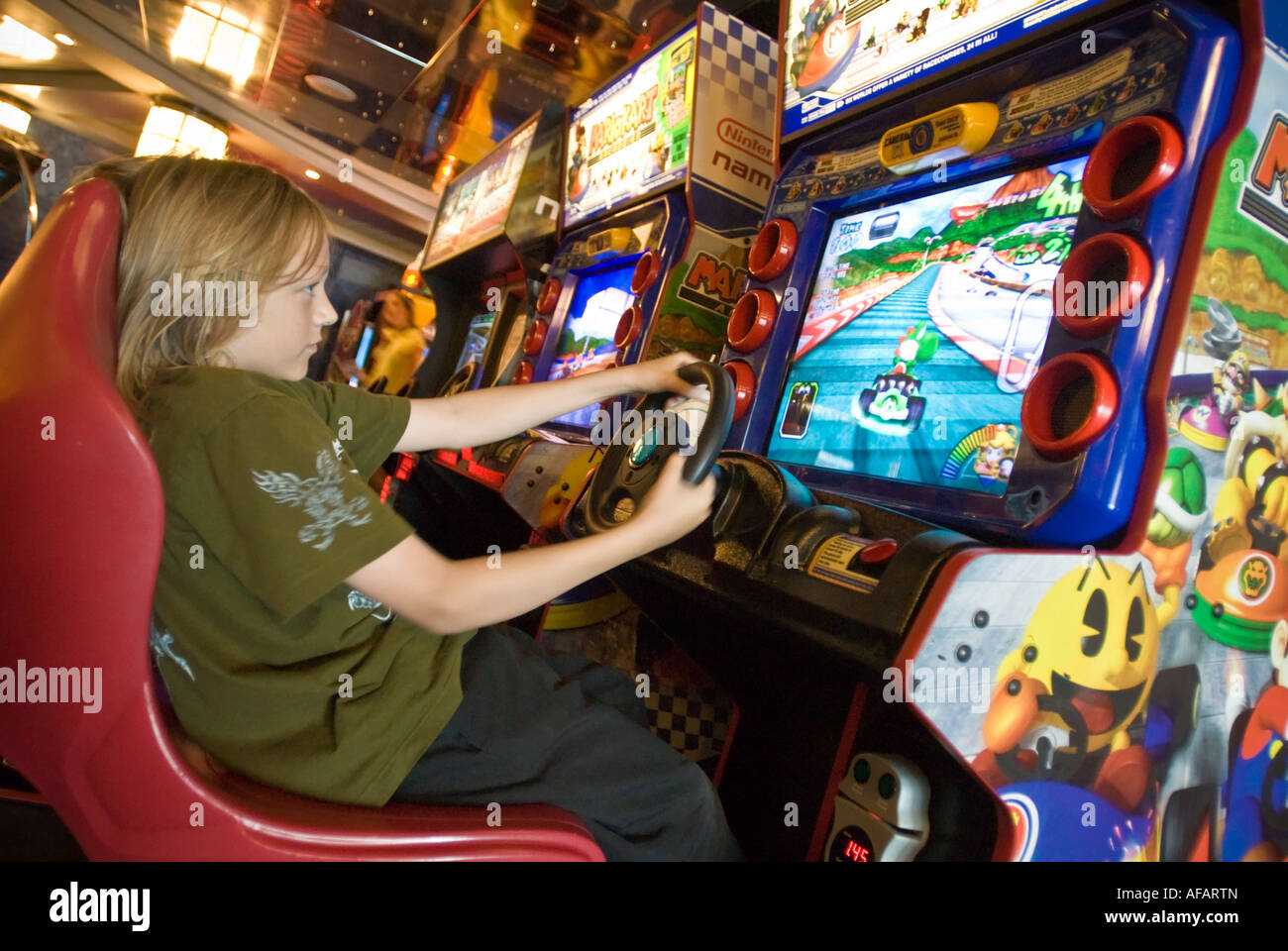 A youngster playing on an arcade game machine Stock Photo - Alamy
