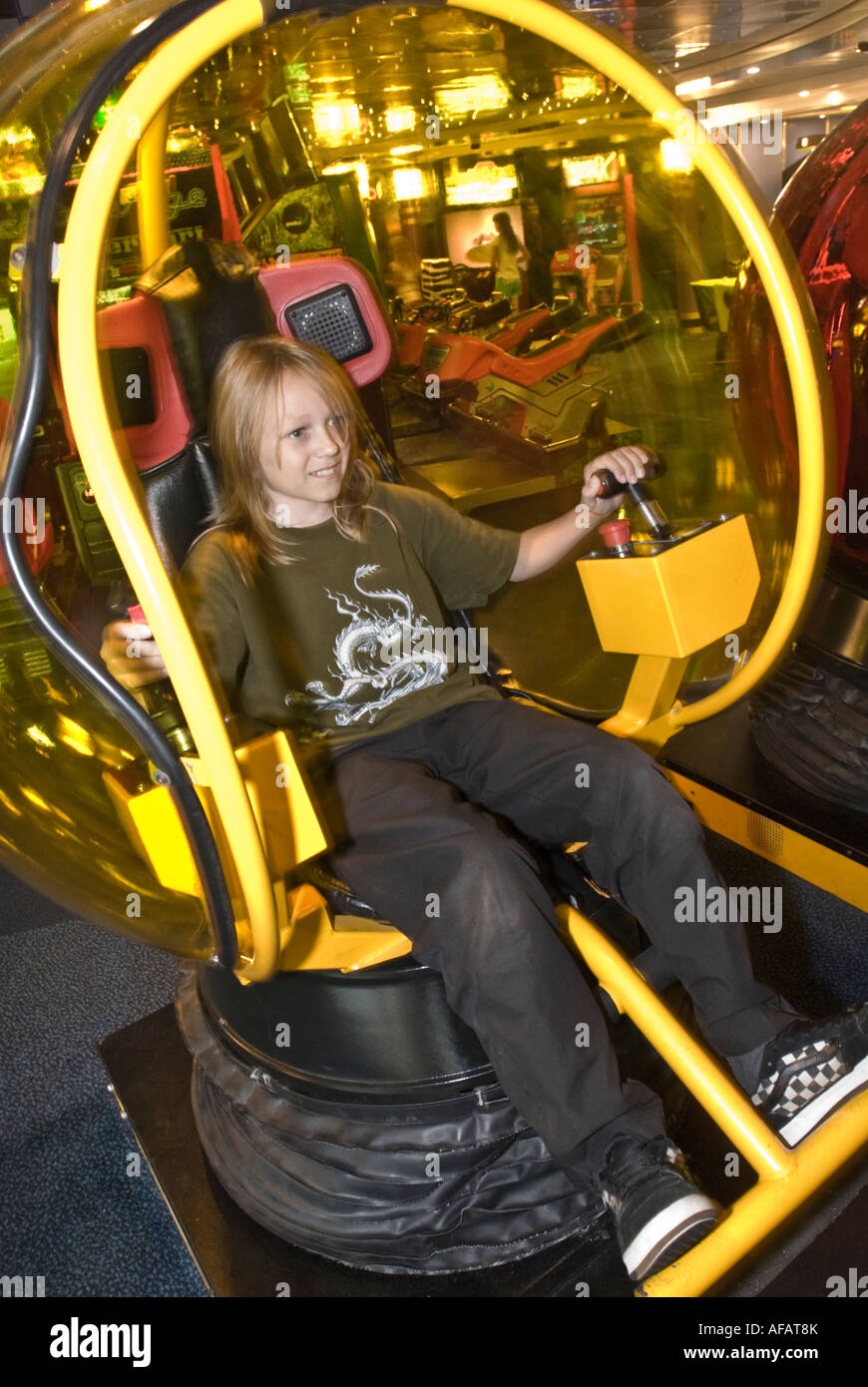 A youngster playing on an arcade flying machine Stock Photo - Alamy