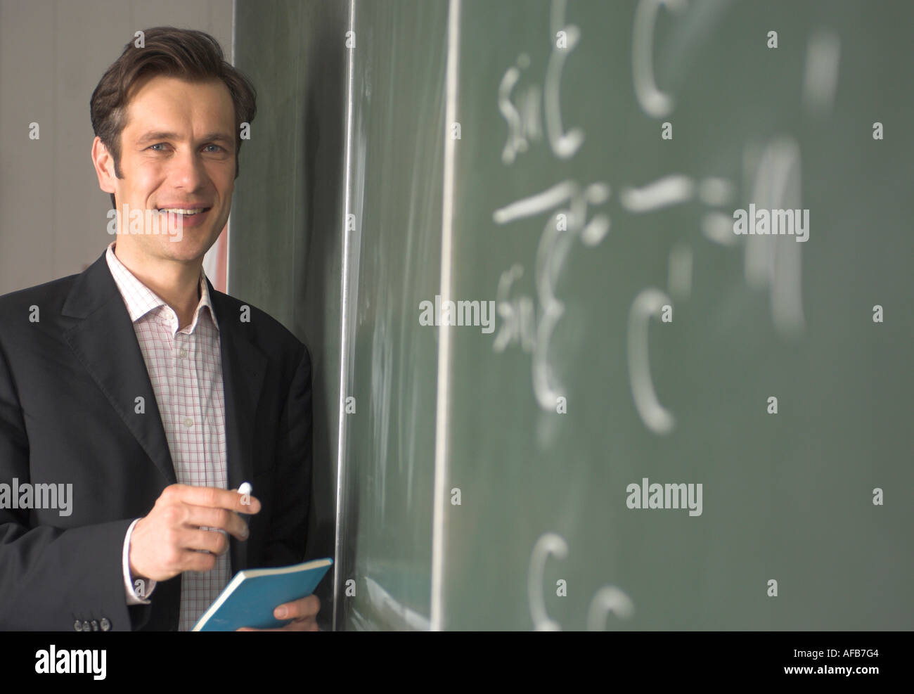 portrait of smiling scientist with formula written on blackboard Stock ...