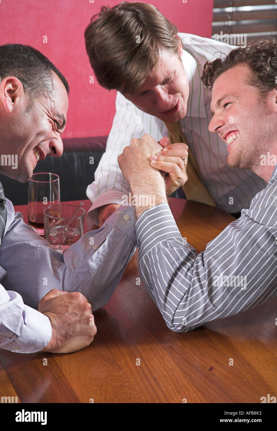 group of friends arm wrestling in bar Stock Photo - Alamy