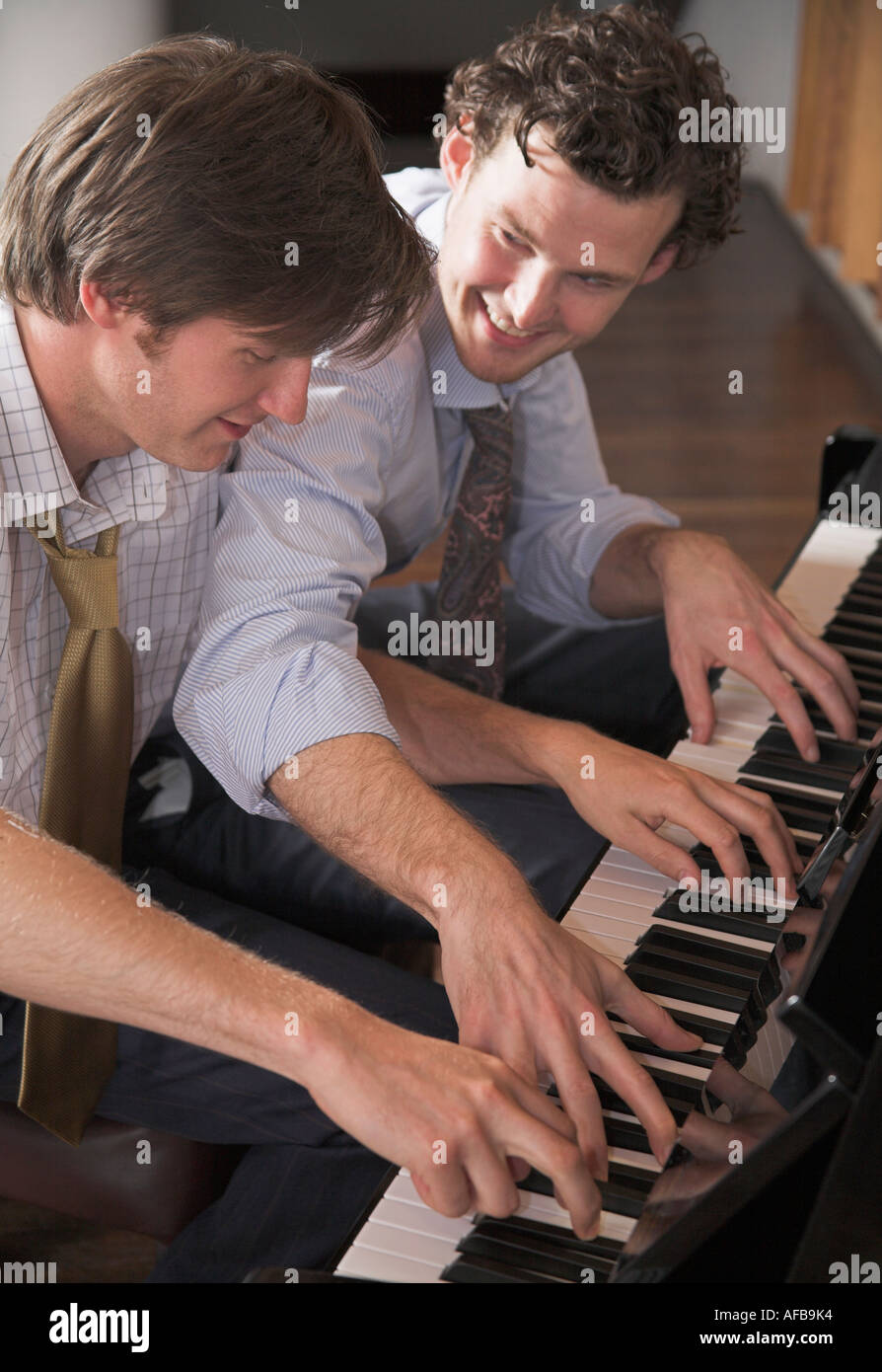 two good friends playing four handed piano Stock Photo - Alamy