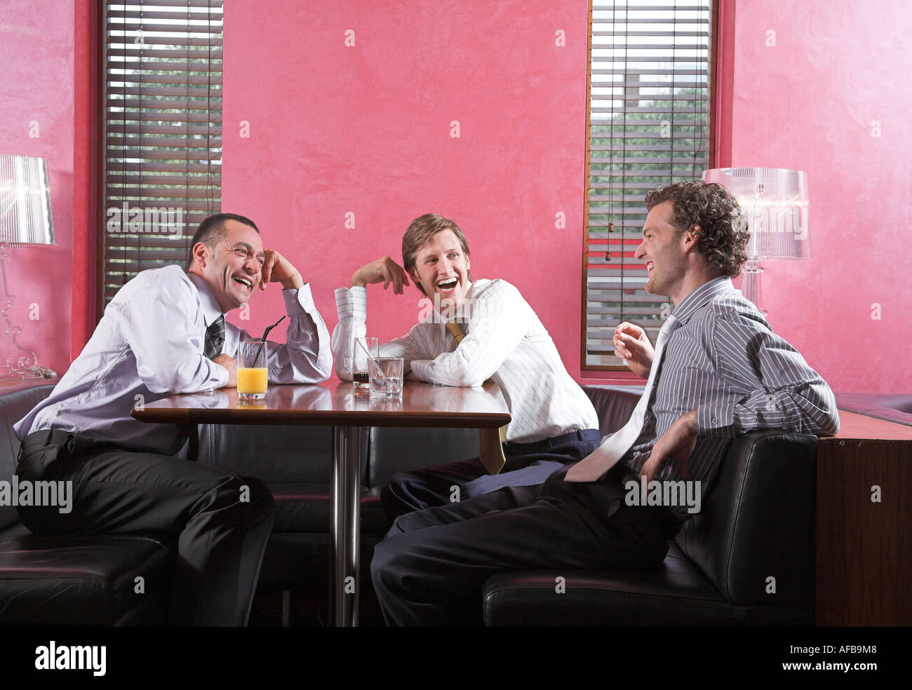 three men enjoying themselves in restaurant Stock Photo - Alamy